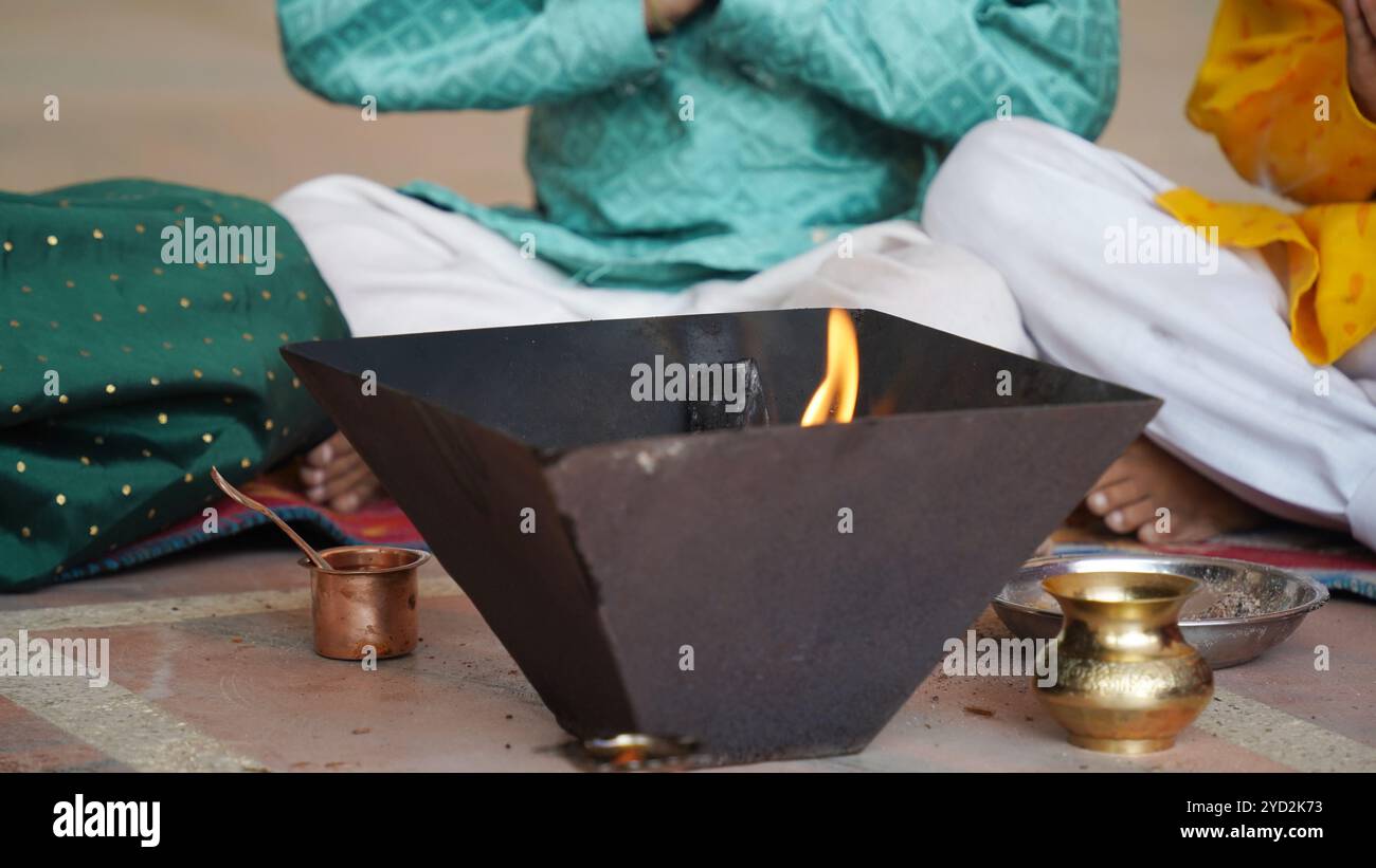 A Hindu family gathers around a sacred fire for Yagya during a festival ...