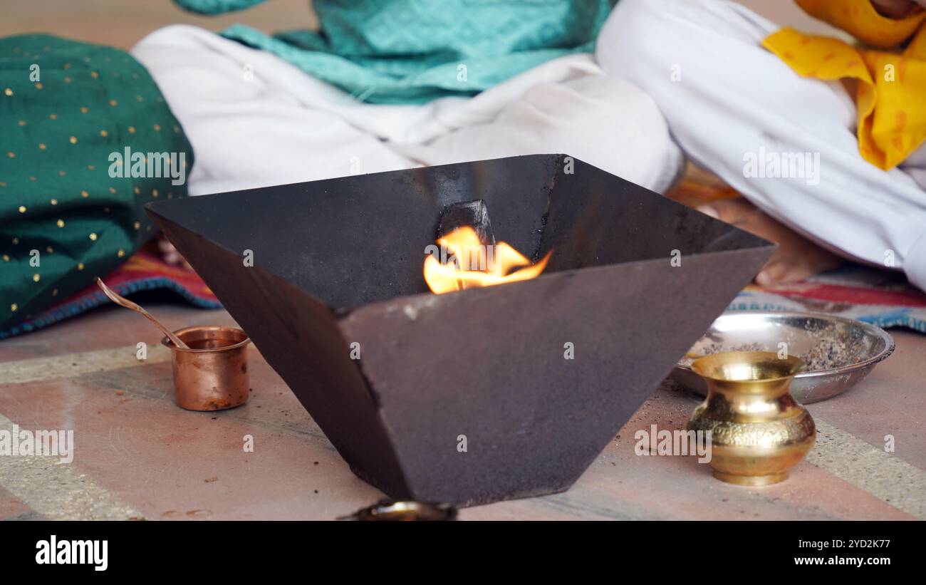 A Hindu family gathers around a sacred fire for Yagya during a festival ...