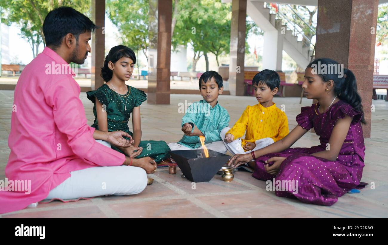 An Indian family in traditional attire performs a Yagya or Havan, led ...