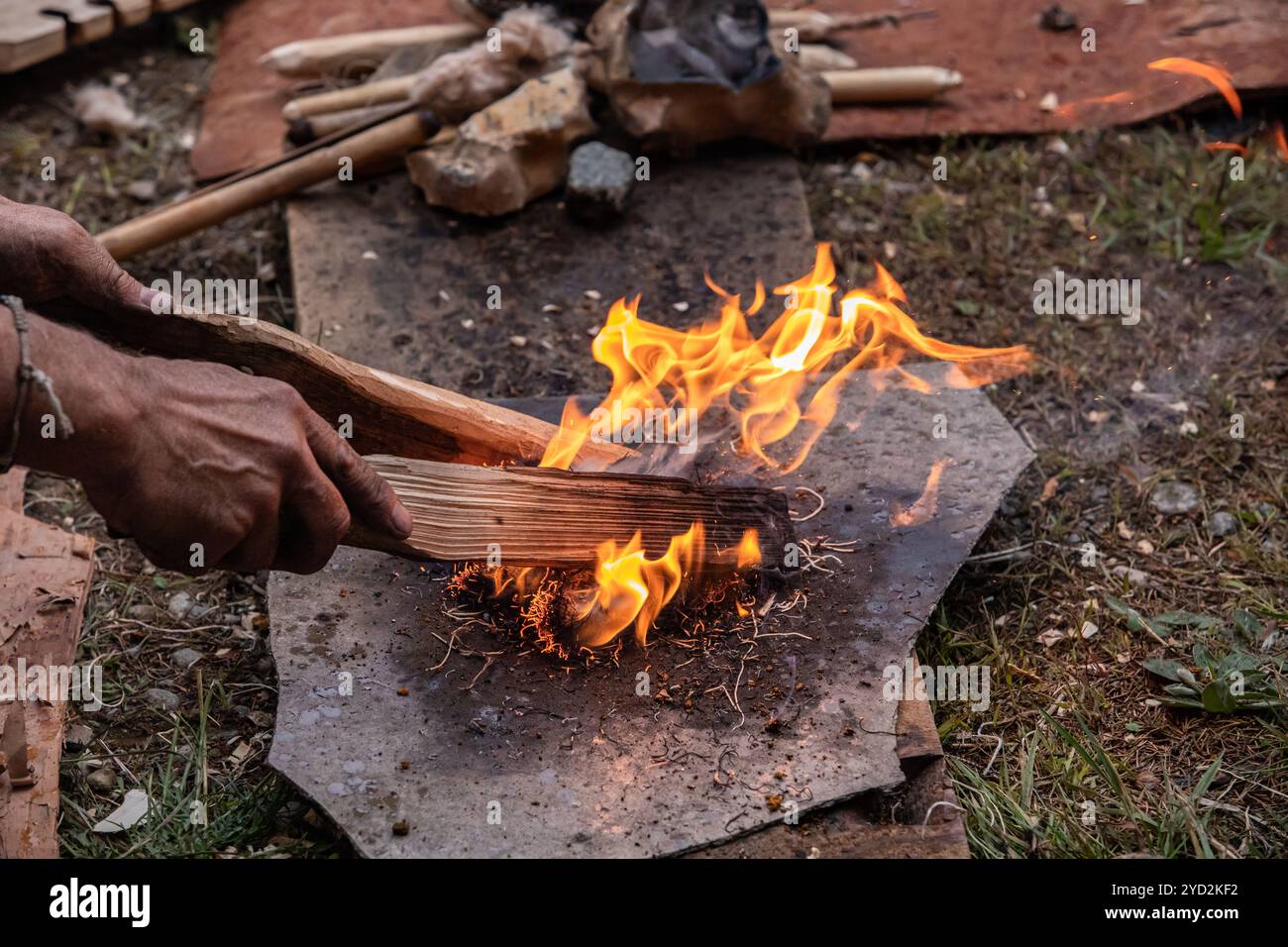 Hands holding sticks in straw as fire starter Stock Photo - Alamy
