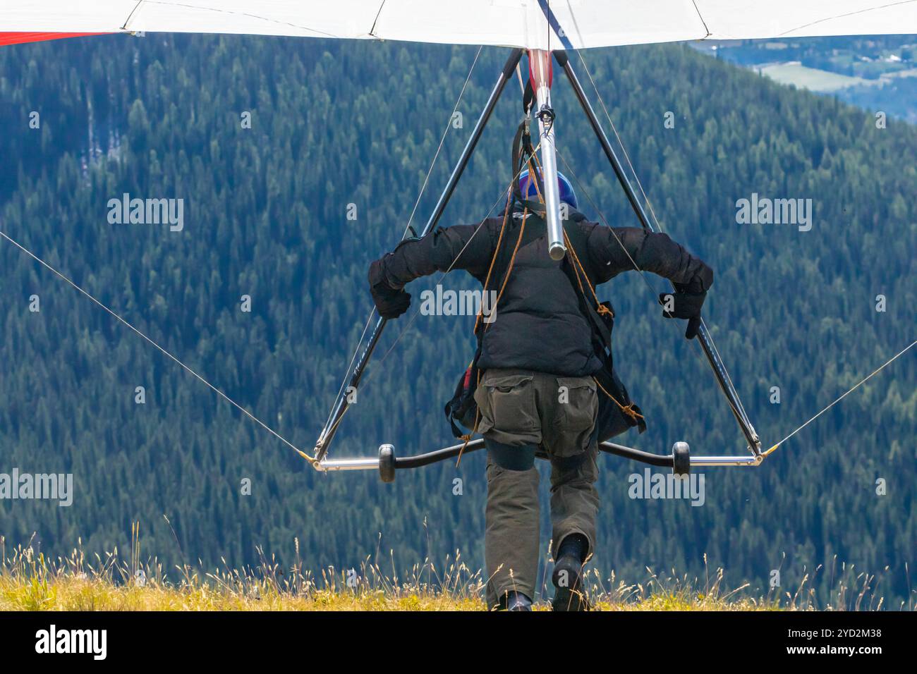 Back view of professional Hang glider man running and taking off. Hang ...
