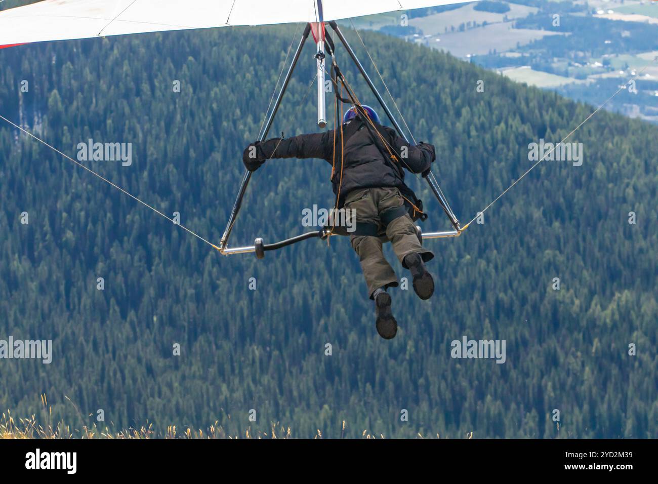 Hang gliding over valley farmlands and mountains Stock Photo - Alamy