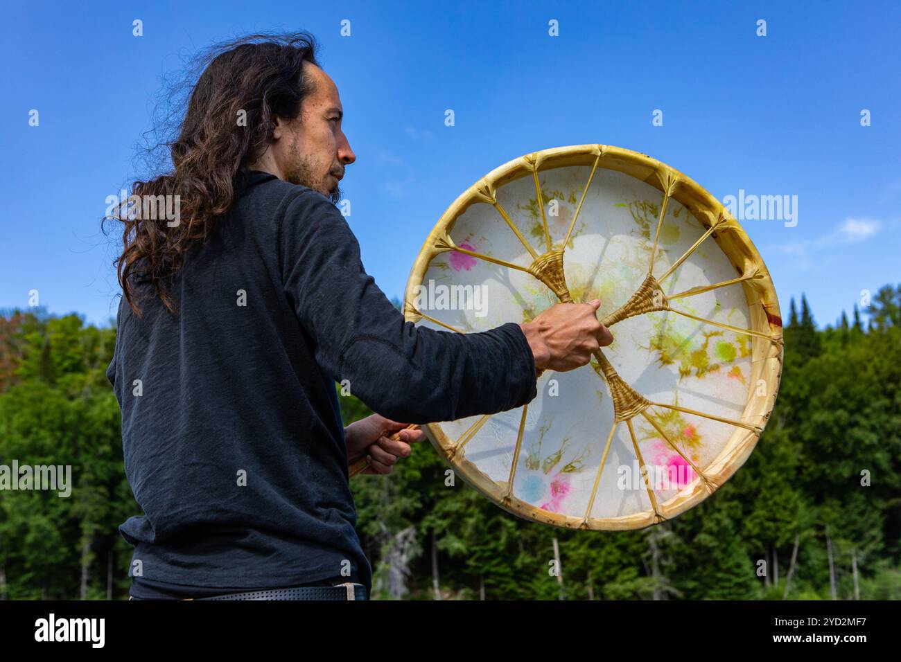 Shamanic male playing sacred drum with stick Stock Photo - Alamy