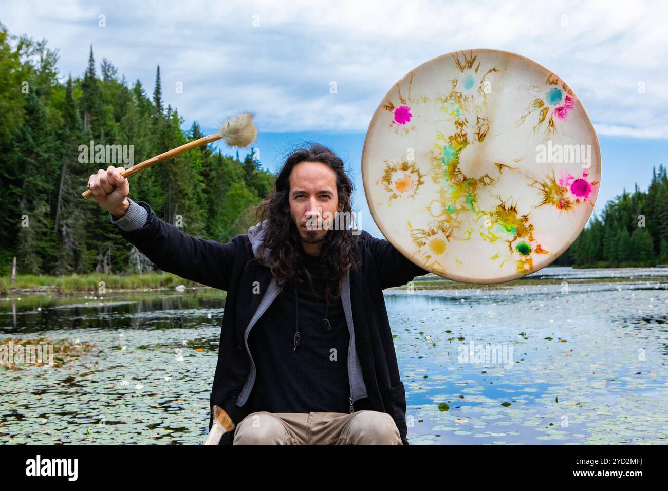 Young man holding sacred drum and fur stick Stock Photo - Alamy