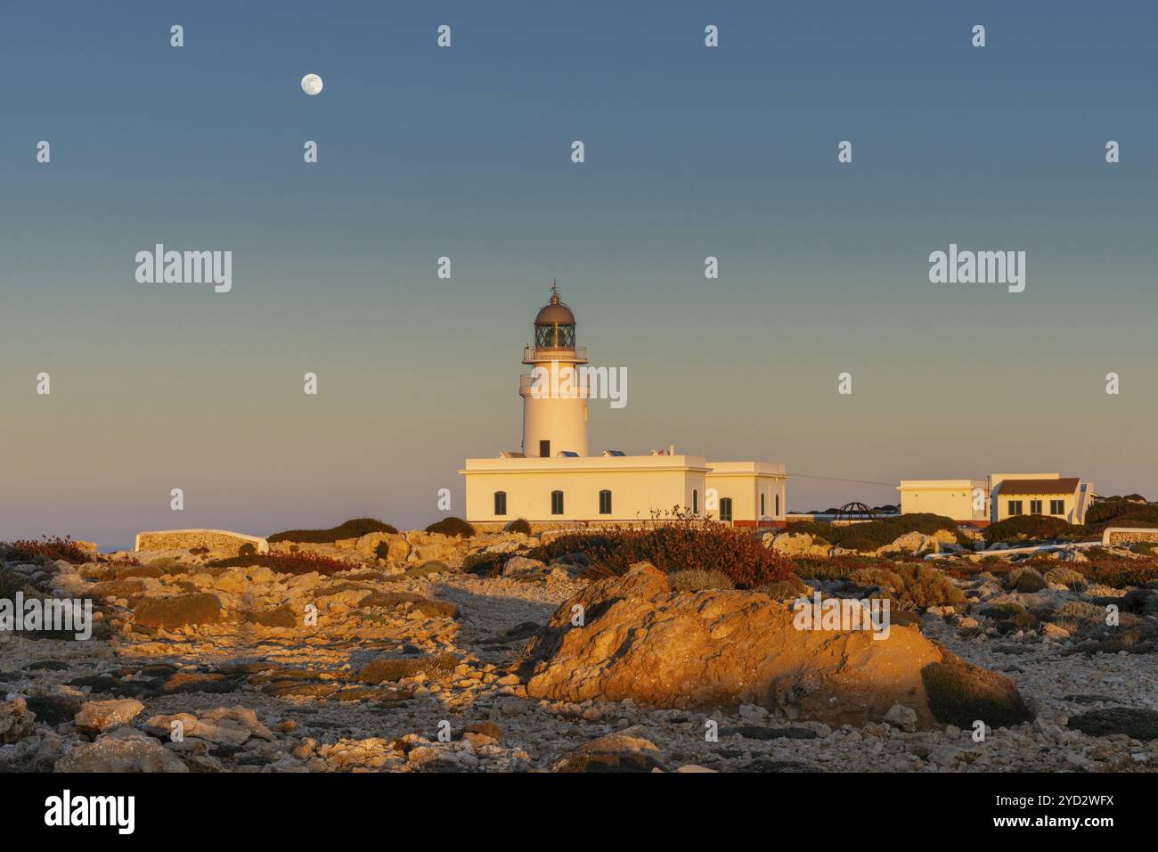 A view of the Cap de Cavalleria Lighthouse on Menorca at sunset with a full moon rising Stock ...