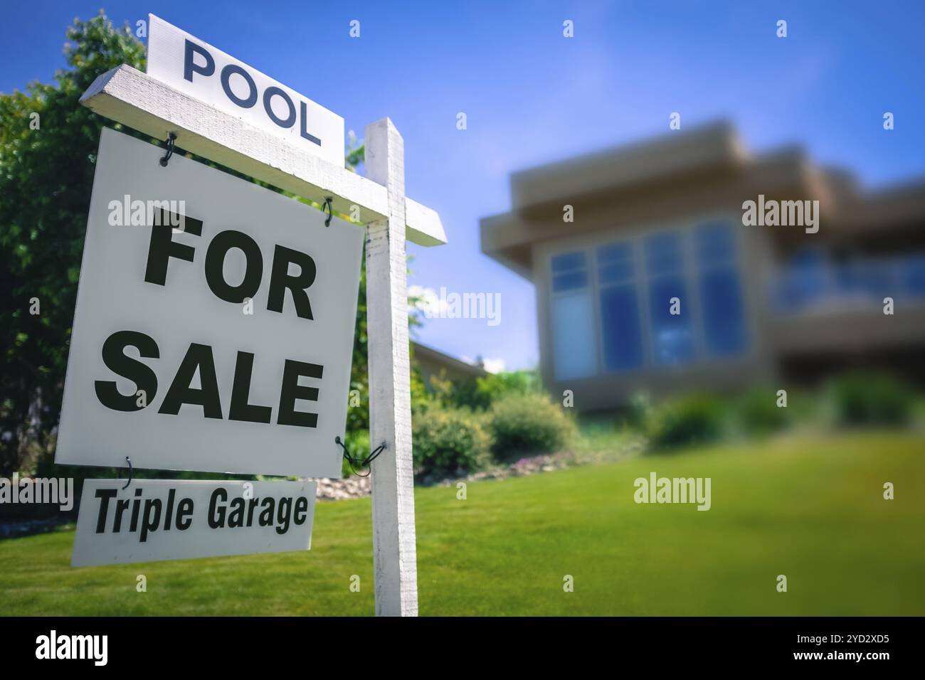 A Sale Sign For A Luxury Home With A Triple Garage And Swimming Pool In ...