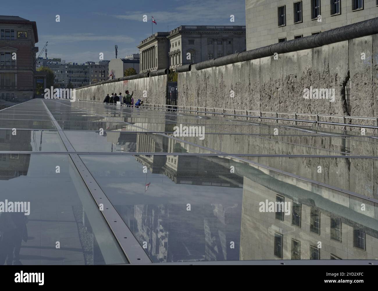 Tourists at a remnant of the Berlin Wall, under the glass roof is the ...