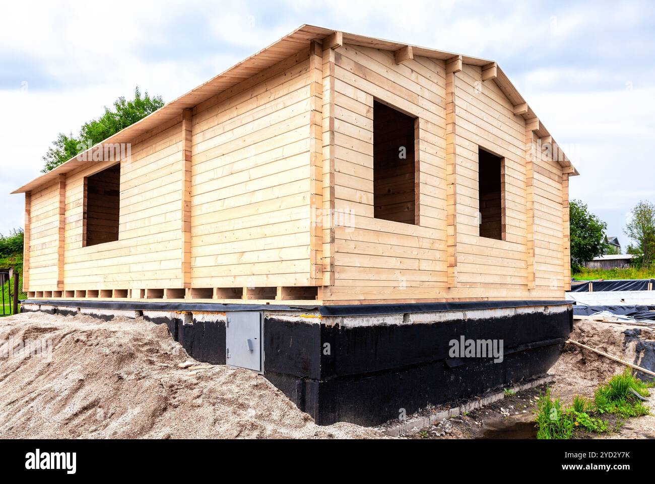 Construction of wooden house on the stone foundation Stock Photo - Alamy