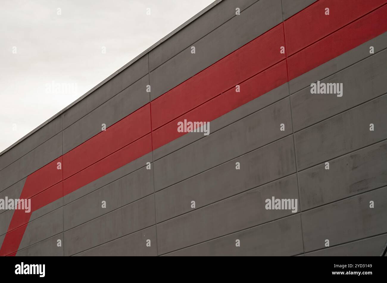 Red architectural details contrast with the grey concrete facade of a ...