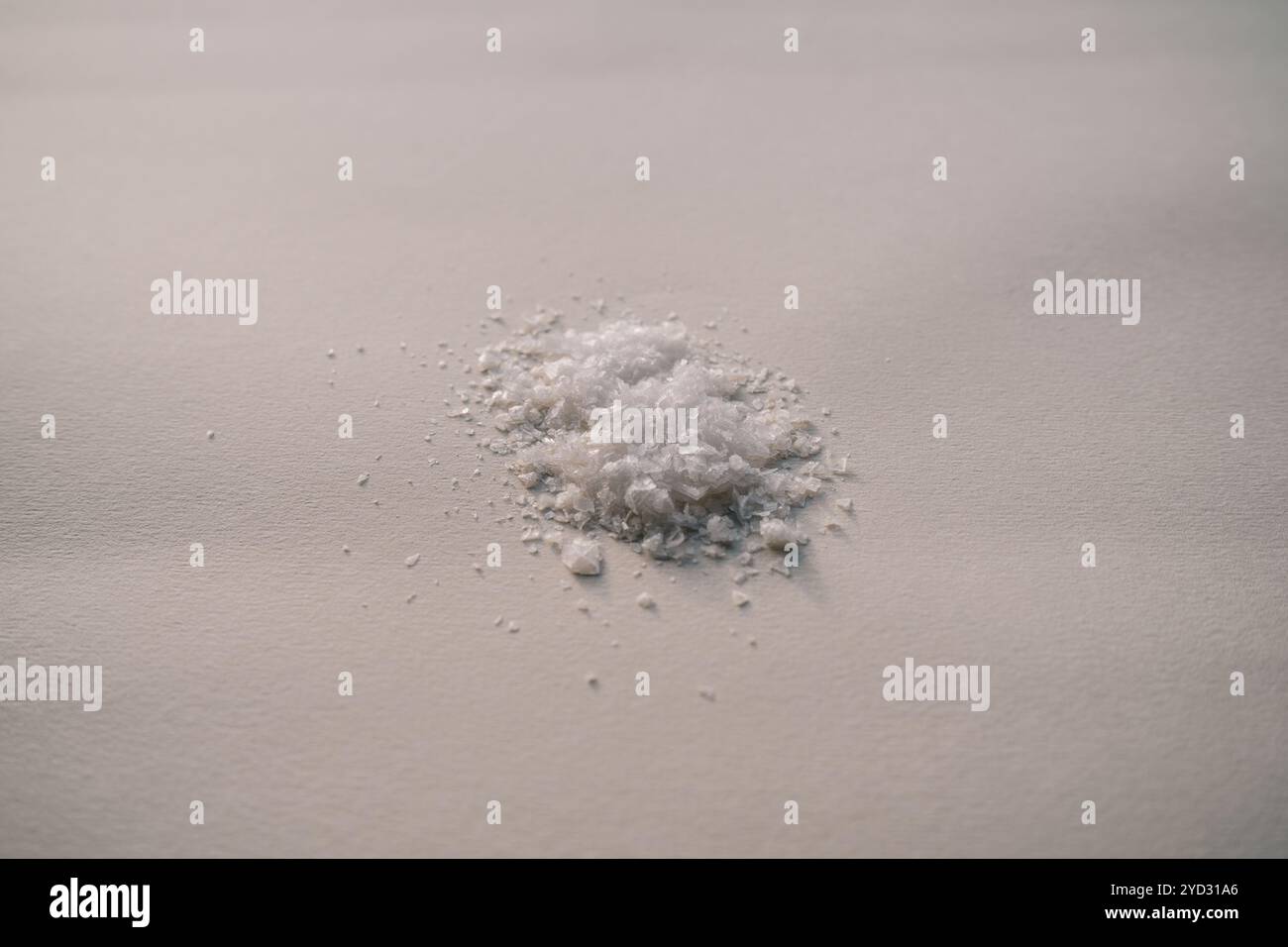 White flake salt against white backround Stock Photo - Alamy