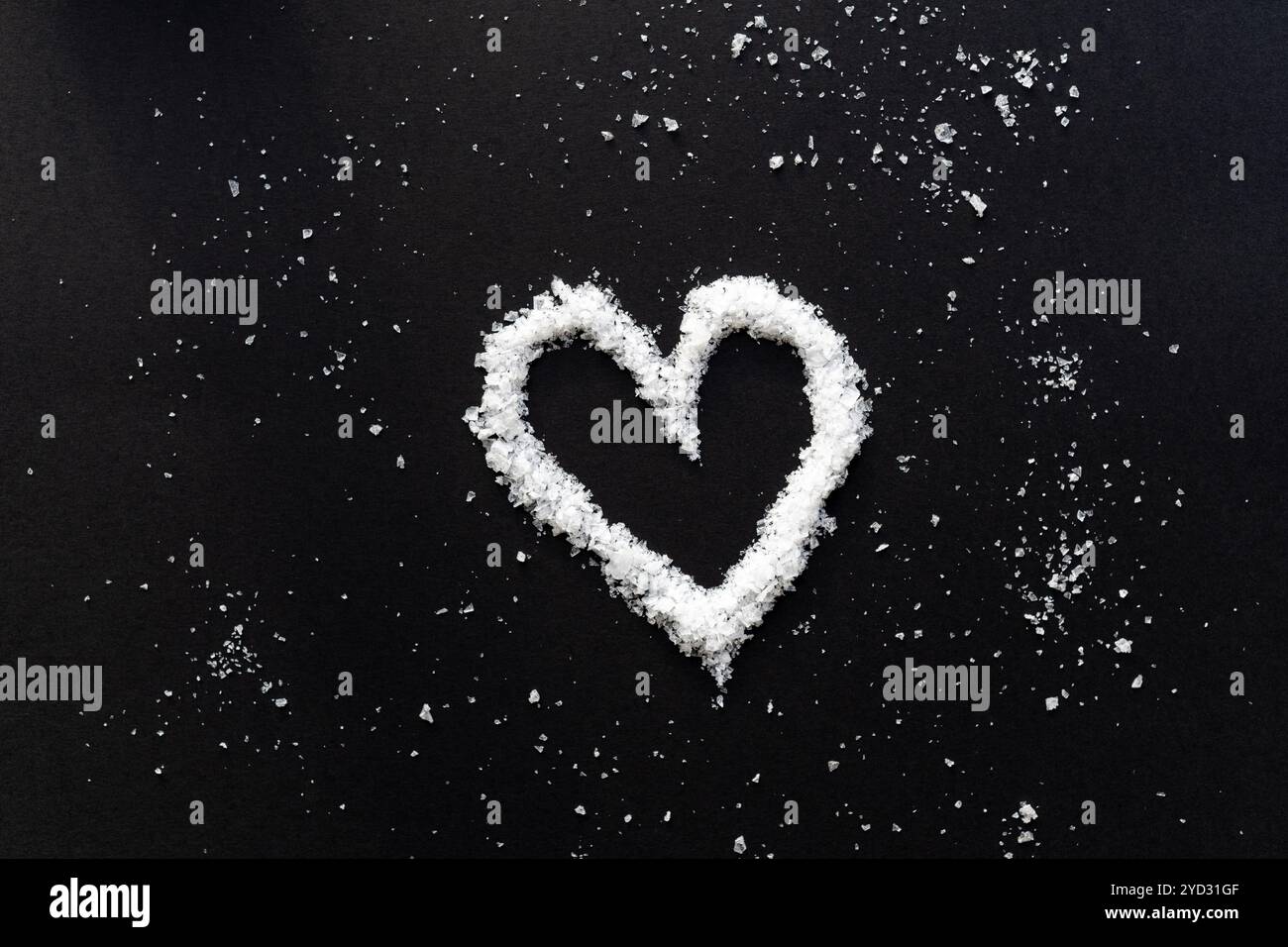White flake salt shaped as a heart against black backround Stock Photo ...