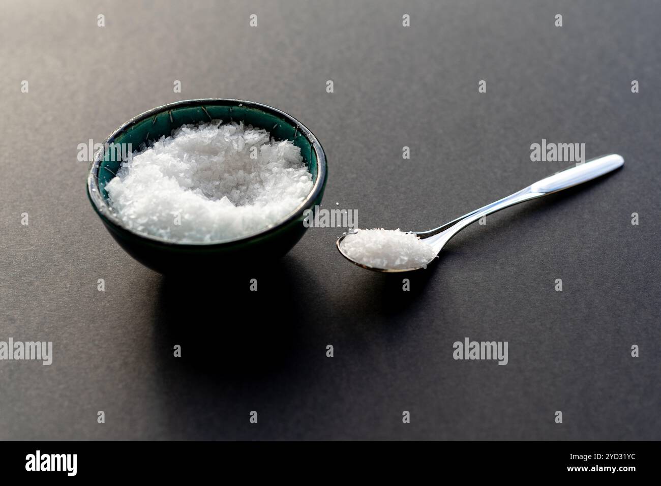 White flake salt in a porcelain cup against black backround Stock Photo ...