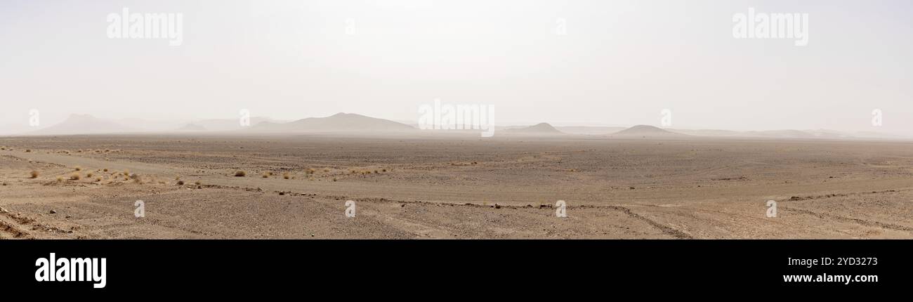 A panorama desert landscape with arid hlls in the distance under a hazy ...