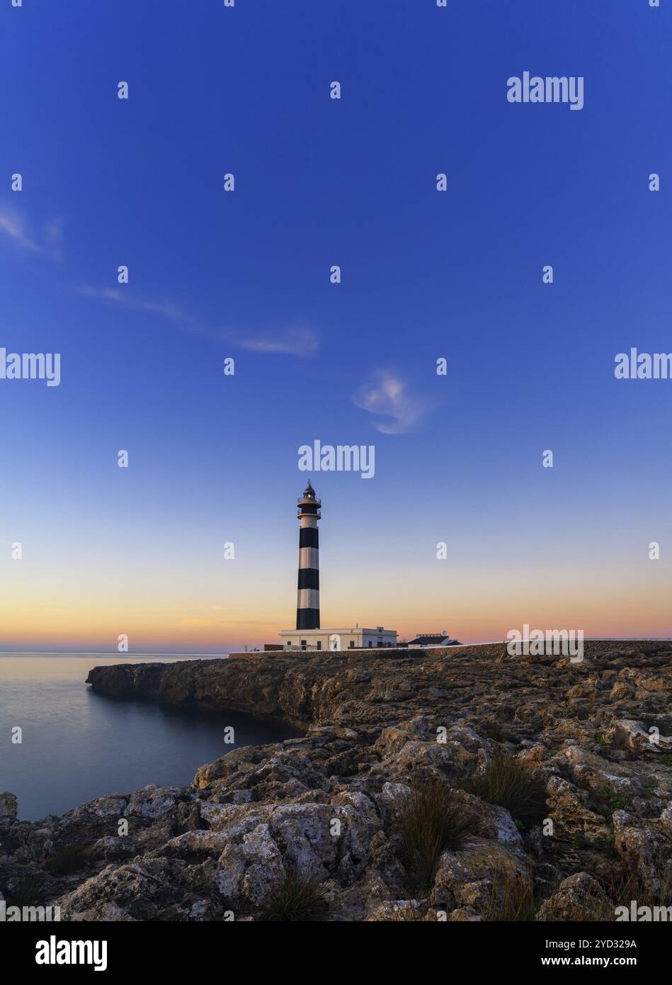 A vertical view of the landmark Cap d'Artrutx lighthouse on Menorca Island just after sunrise ...