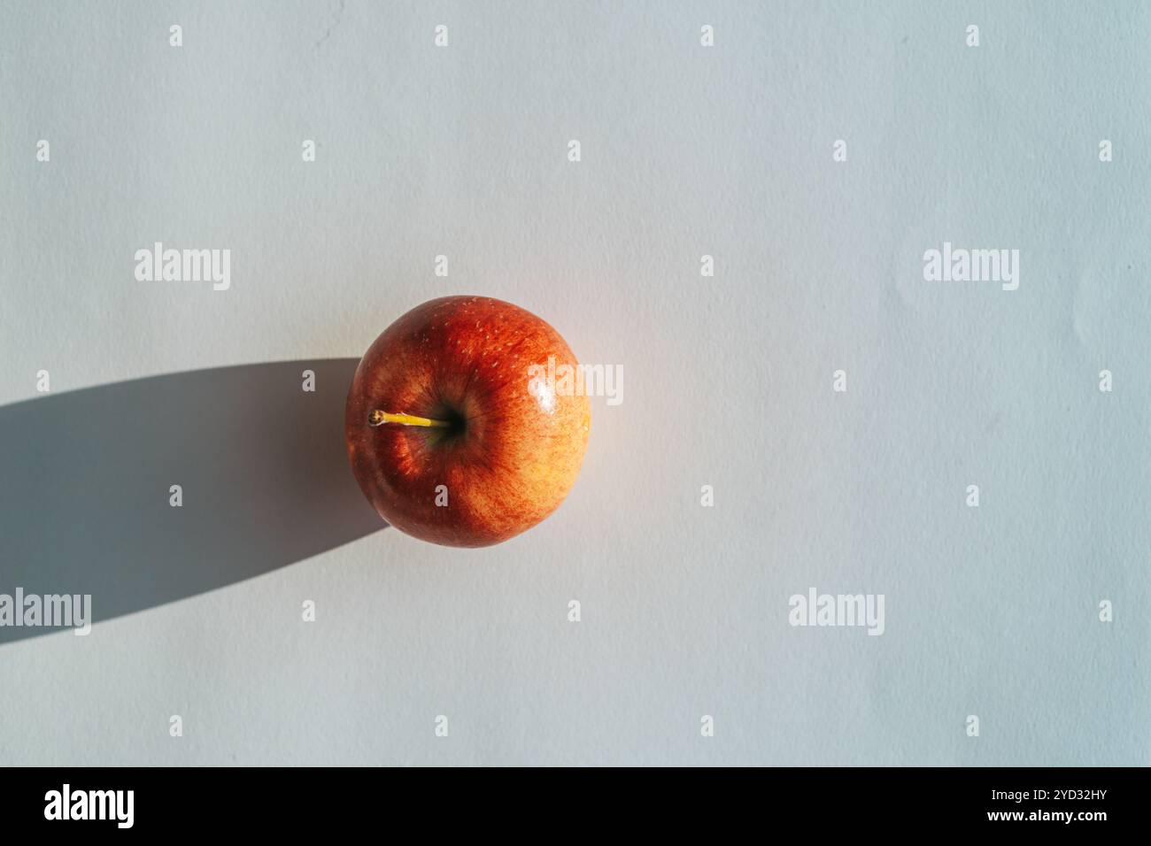 Red apple forming a shadow against white backround Stock Photo - Alamy