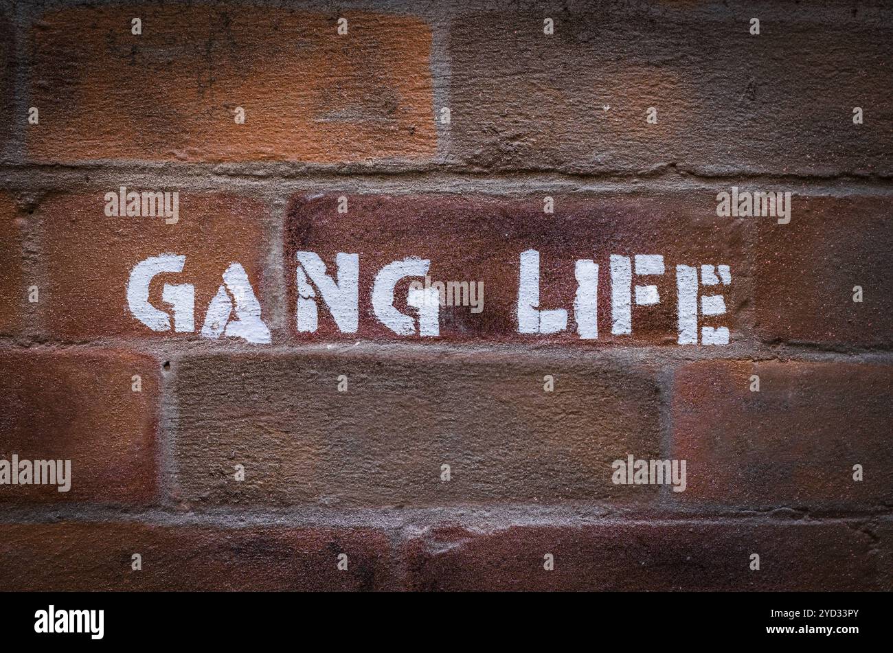 Urban Gang Life Stencil Graffiti On A Red Brick Wall Stock Photo - Alamy
