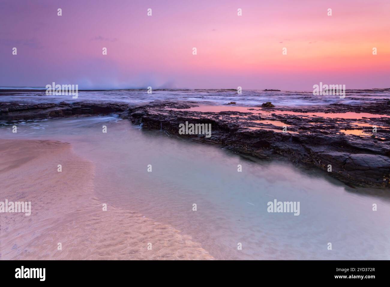 Pretty sunrise over the beach and rock shelf with reflections Stock ...