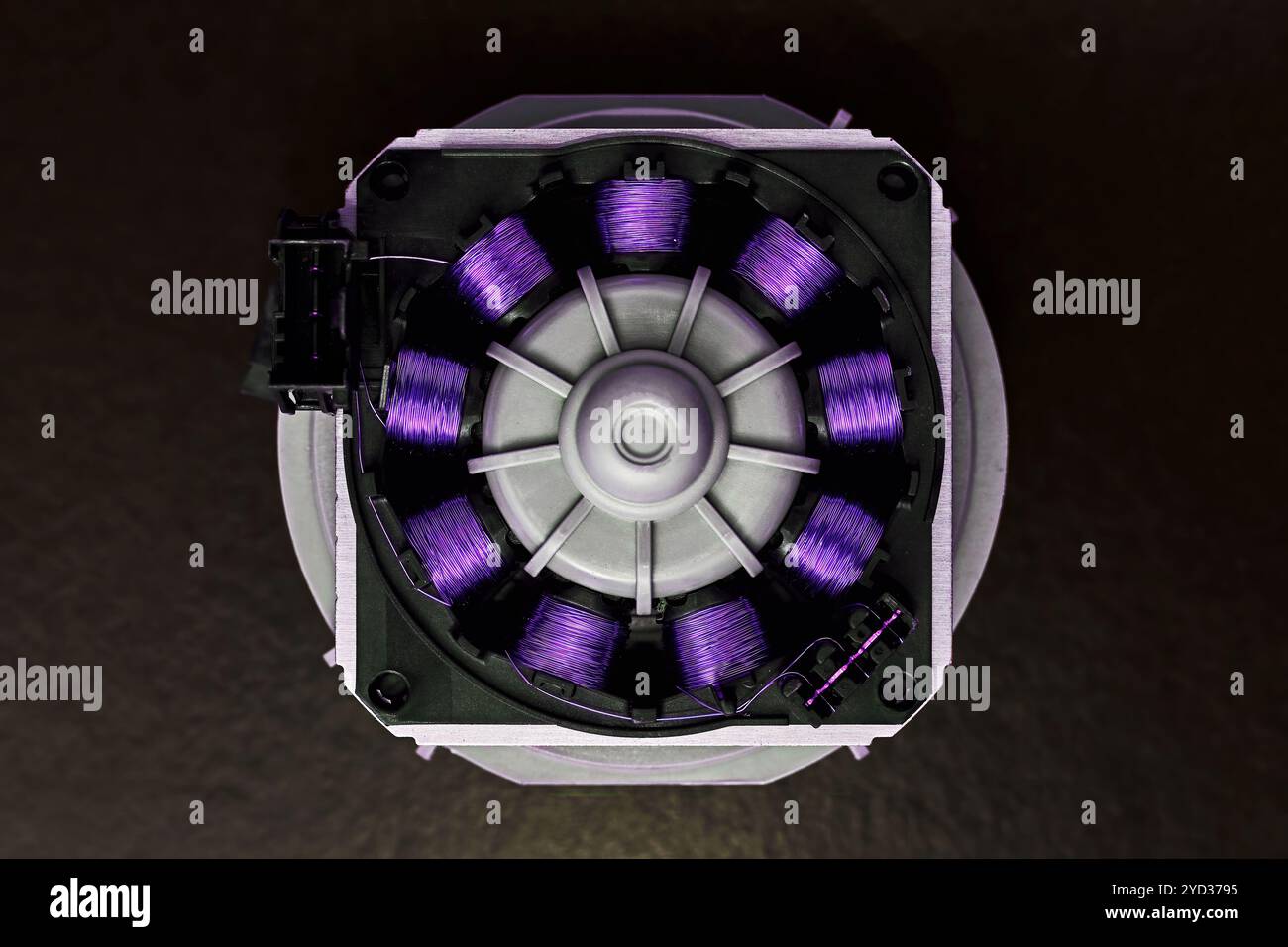 An electric motor with purple coils. The motor is in a disassembled ...