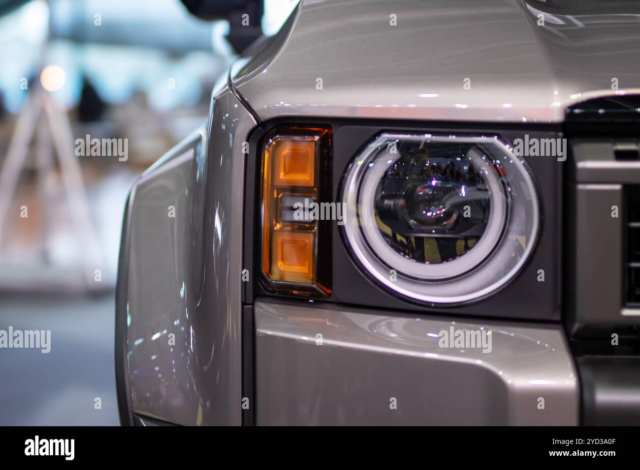 The image features a detailed closeup view of the headlight of a sleek ...