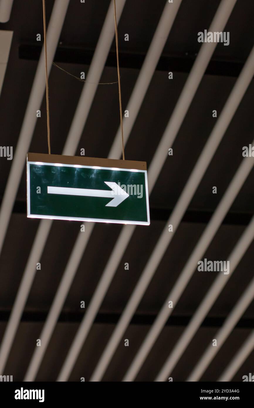 There is a bright green exit sign that features an arrow distinctly ...