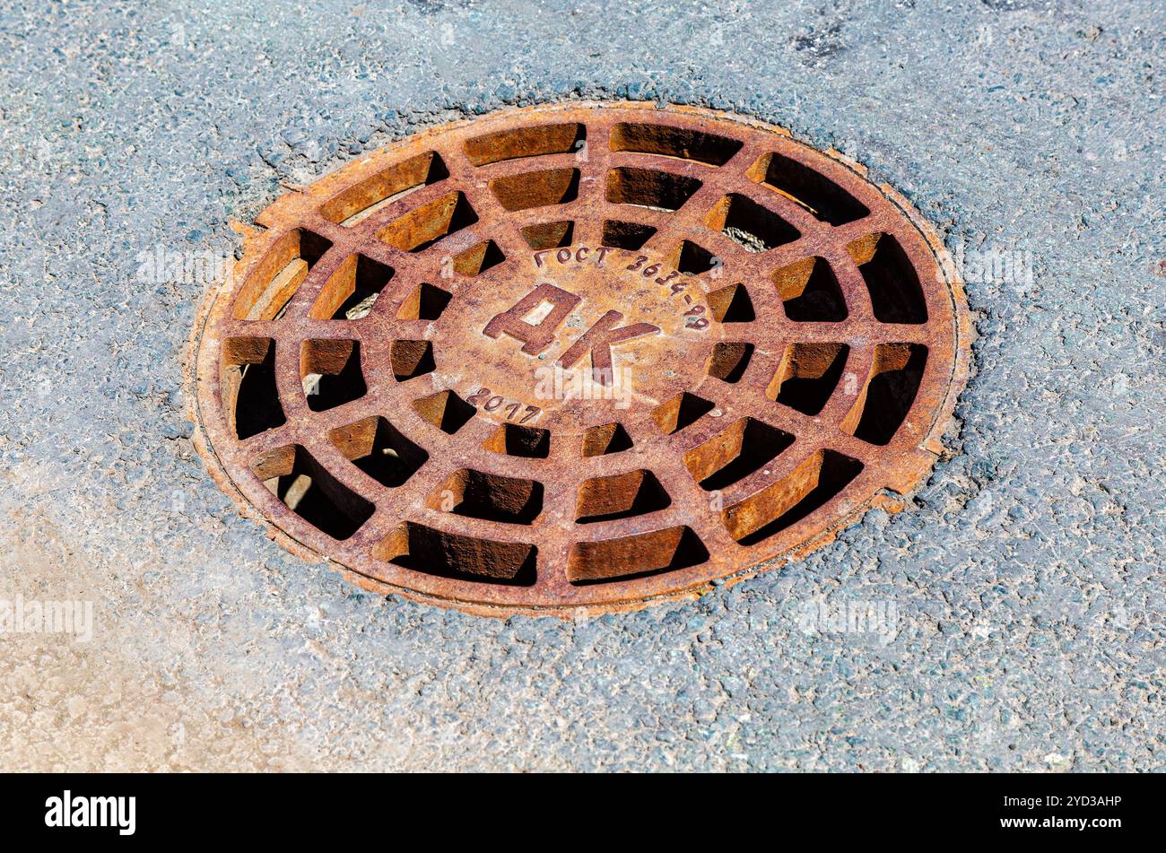 Rusty metal manhole cover on the asphalt road Stock Photo - Alamy
