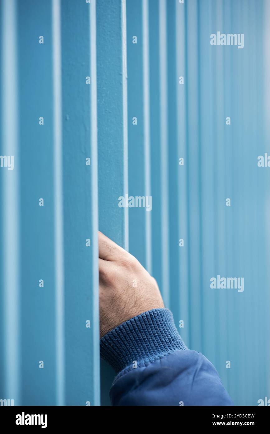 Mans hand over bars Stock Photo - Alamy