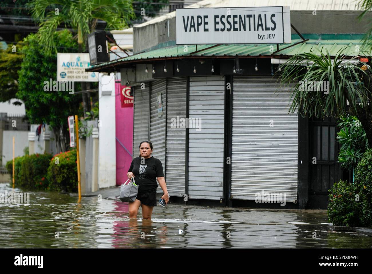 A resident crosses flooded streets caused by Tropical Storm Trami on ...