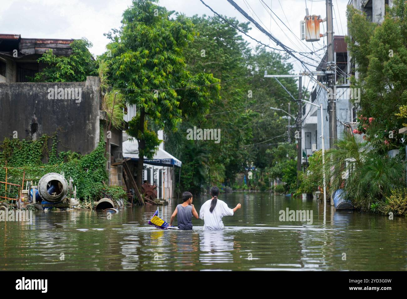 Residents walk along the flooded village caused by Tropical Storm Trami ...