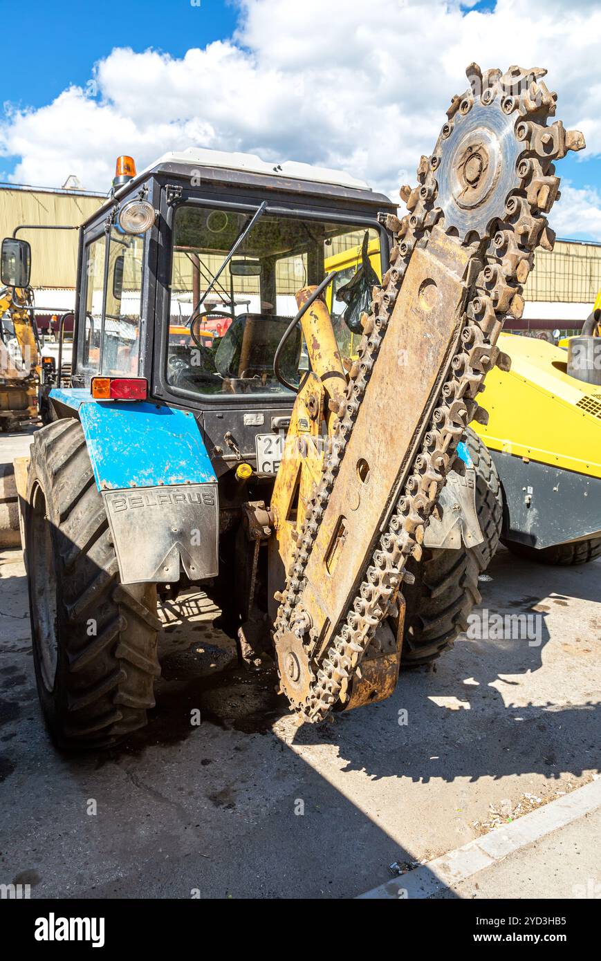Wheeled tractor with a hinged device for digging trenches Stock Photo ...
