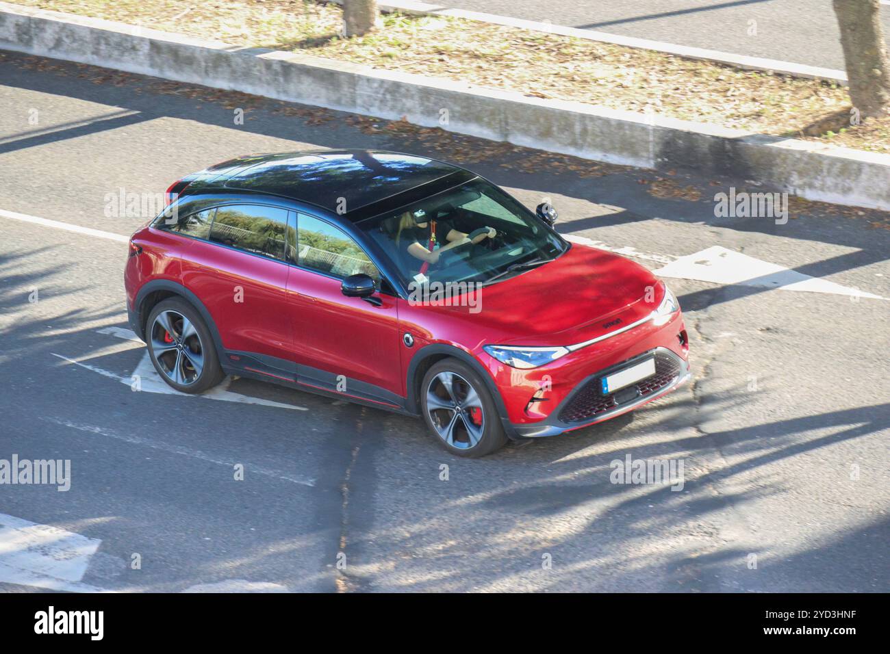 Red smart 3 electric car driving on a city road, offering a glimpse ...