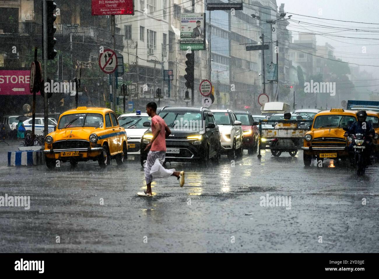 A man runs to cross a busy street during heavy rain following tropical ...