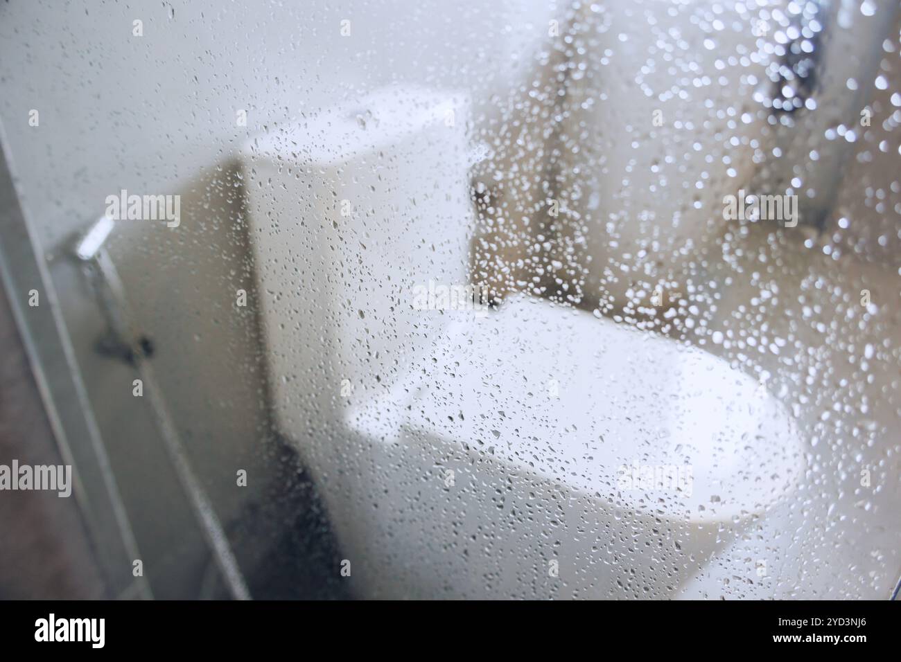 Wet moist water dew splashing on the glass wall with blur toilet closet ...