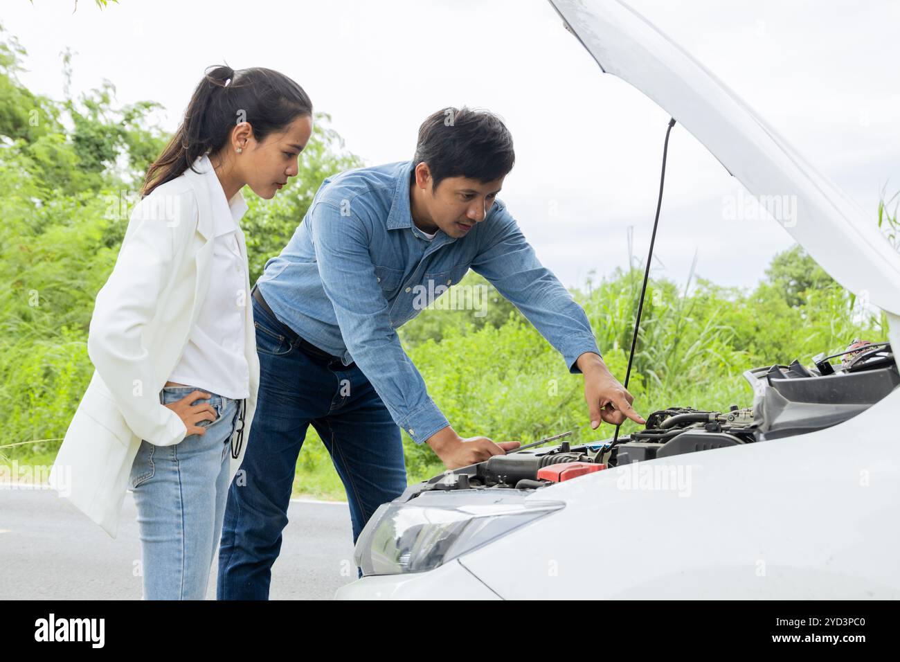 Women Car Broken on the Road. Young Couple Inspecting Car Engine on a ...