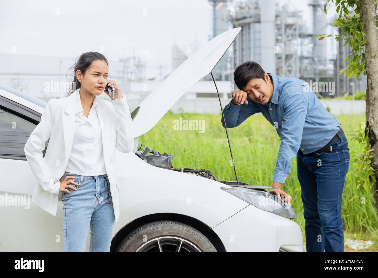 Women Car Broken on the Road. Young Couple Inspecting Car Engine on a ...