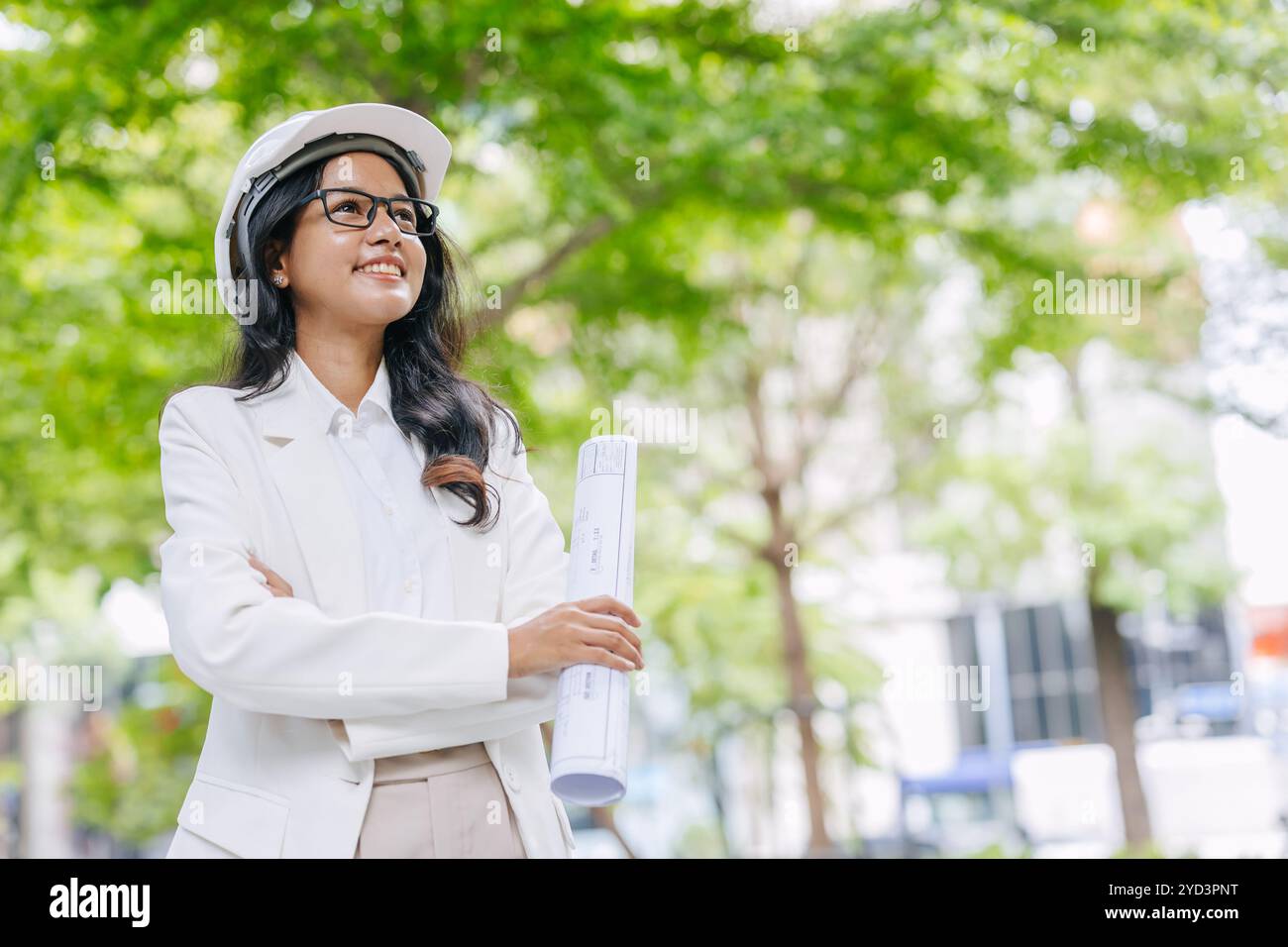 Portrait smart young engineer women standing with floorplan at green ...