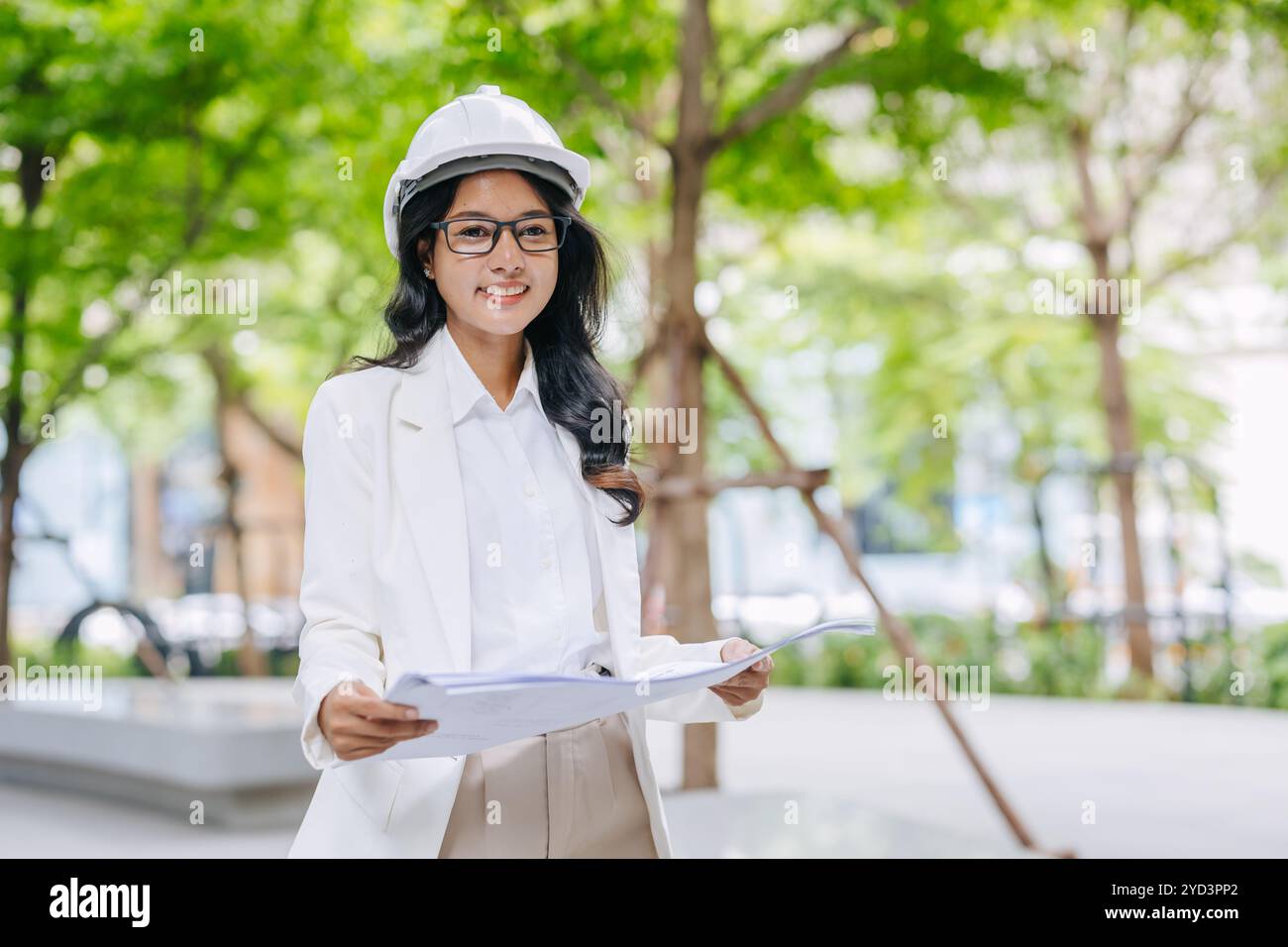 Portrait smart young engineer women standing with floorplan at green ...