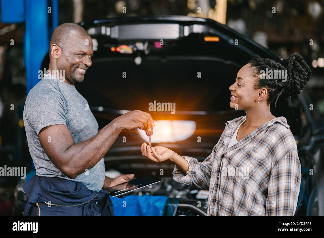 Garage worker mechanic male hand giving a car key for vehicle to ...