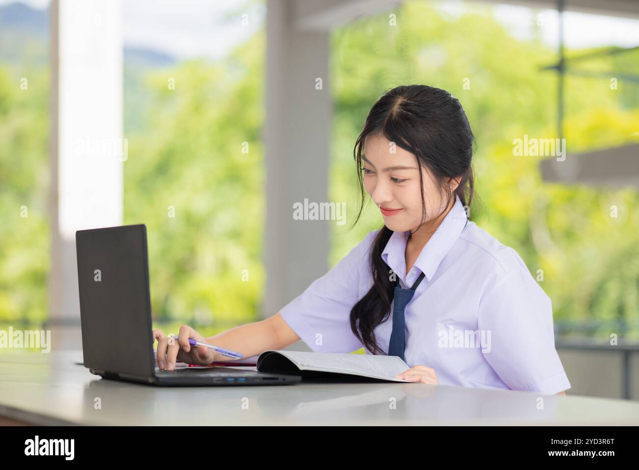 happy school uniform teen girl using laptop computer to do homework ...