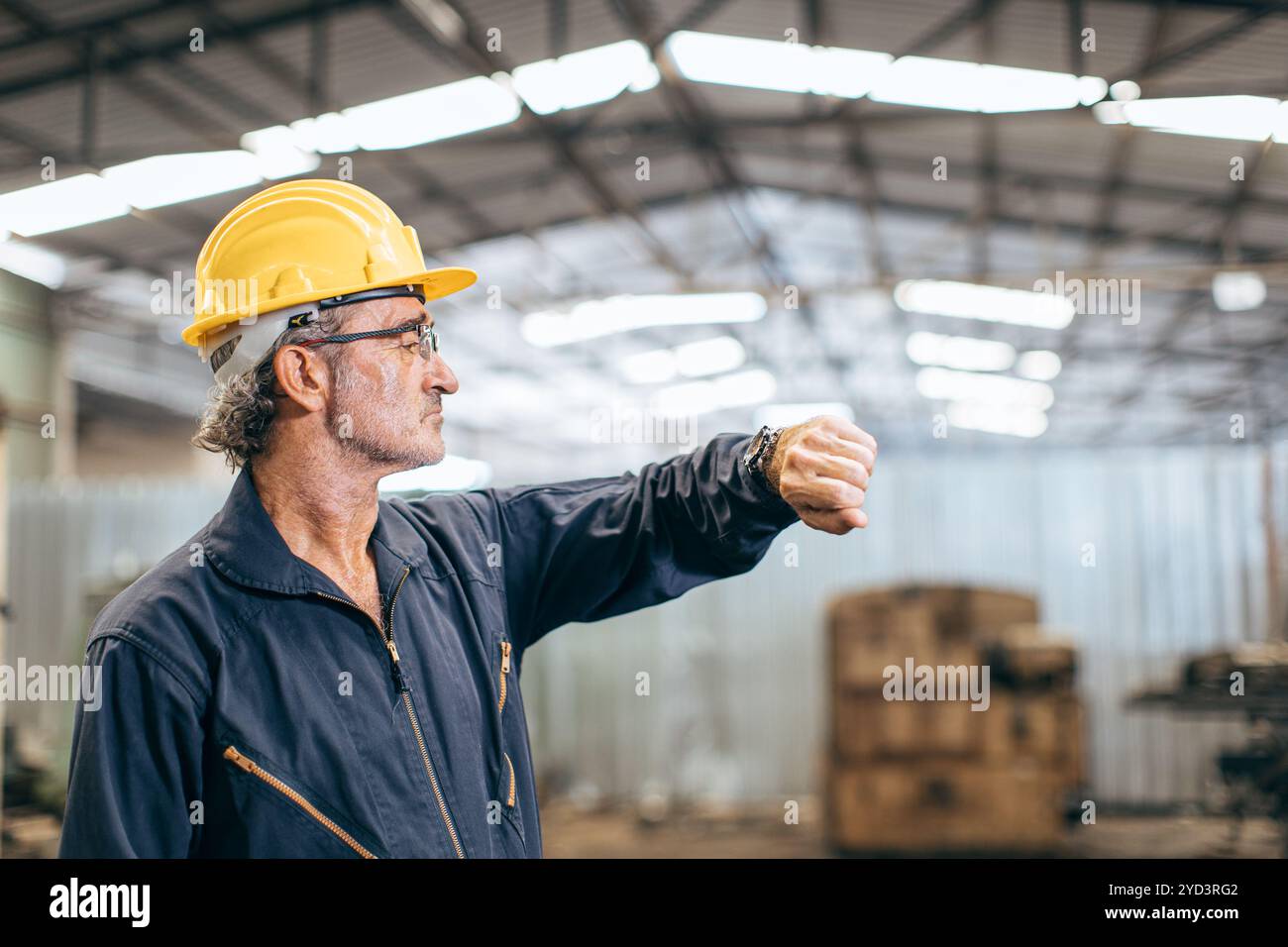 Senior worker looking at to a clock on his wrist watch waiting working ...