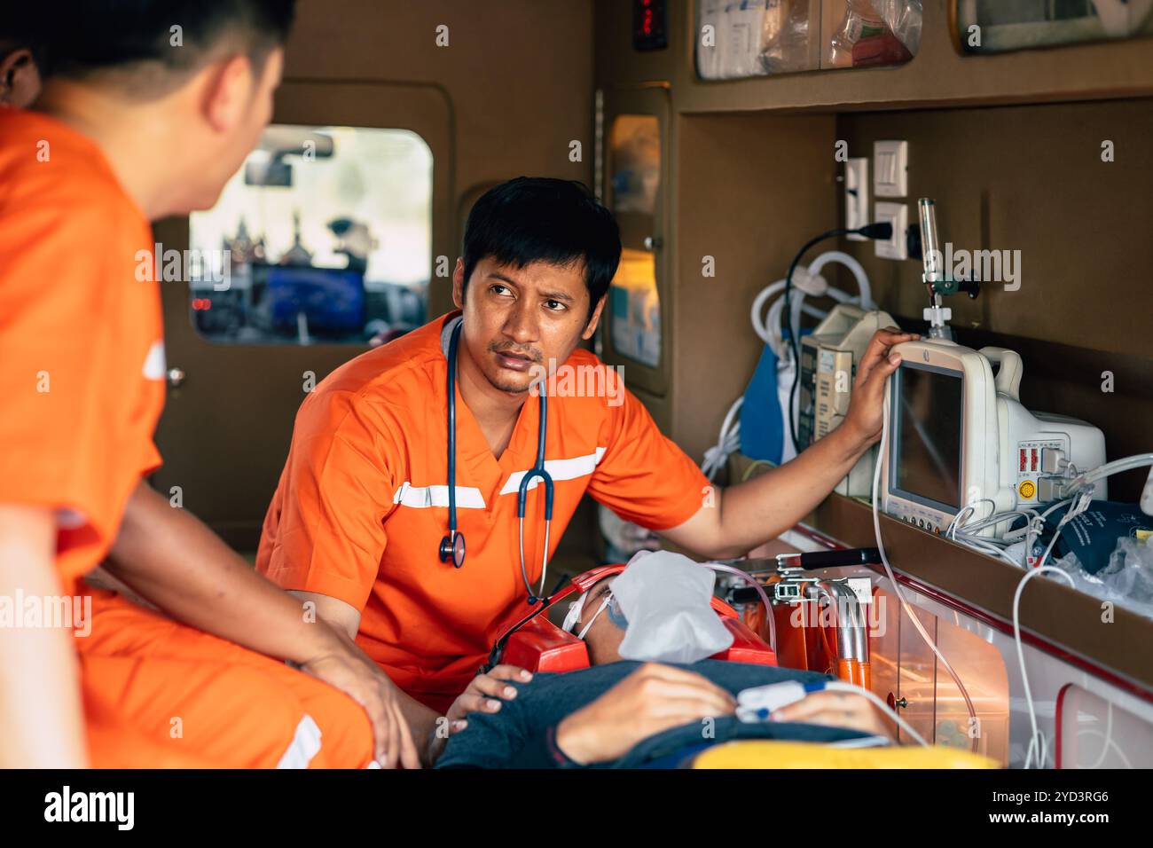 Paramedics attending to a patient inside an ambulance, providing ...