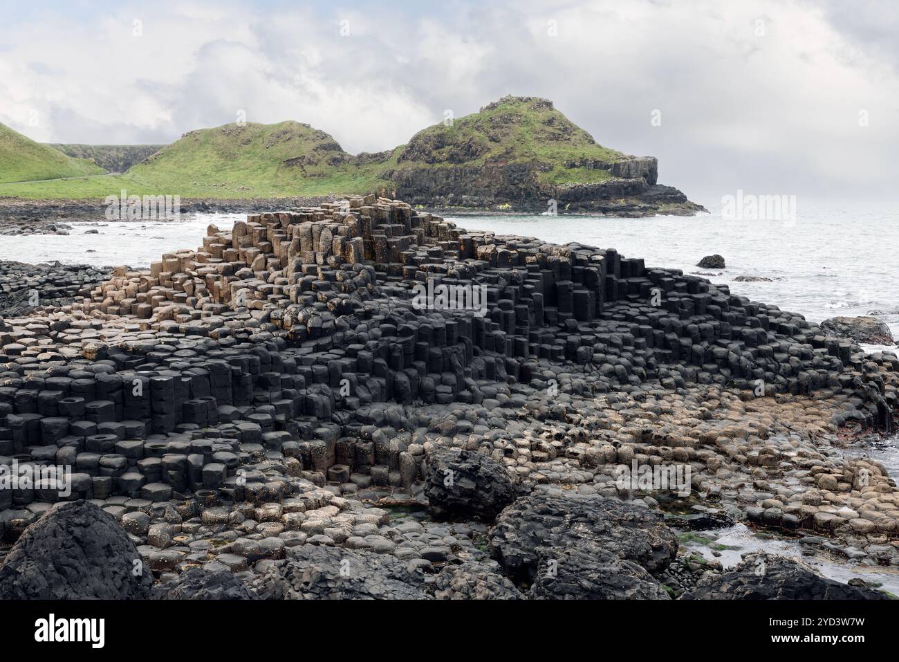 Basalt columns of Giant's Causeway with the hilly Northern Irish coast ...