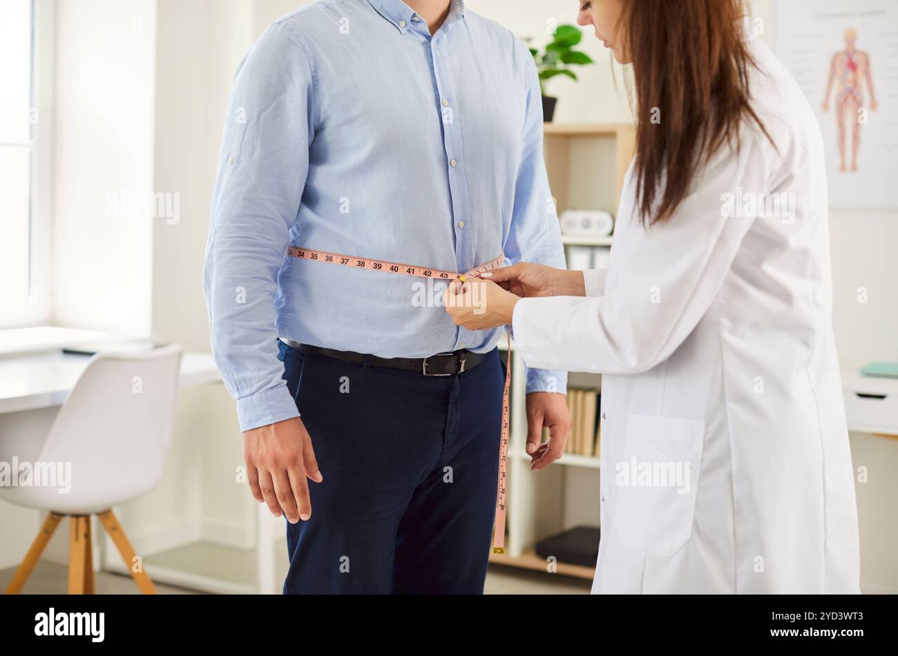 Female doctor physiotherapist measure waist with measuring tape for ...