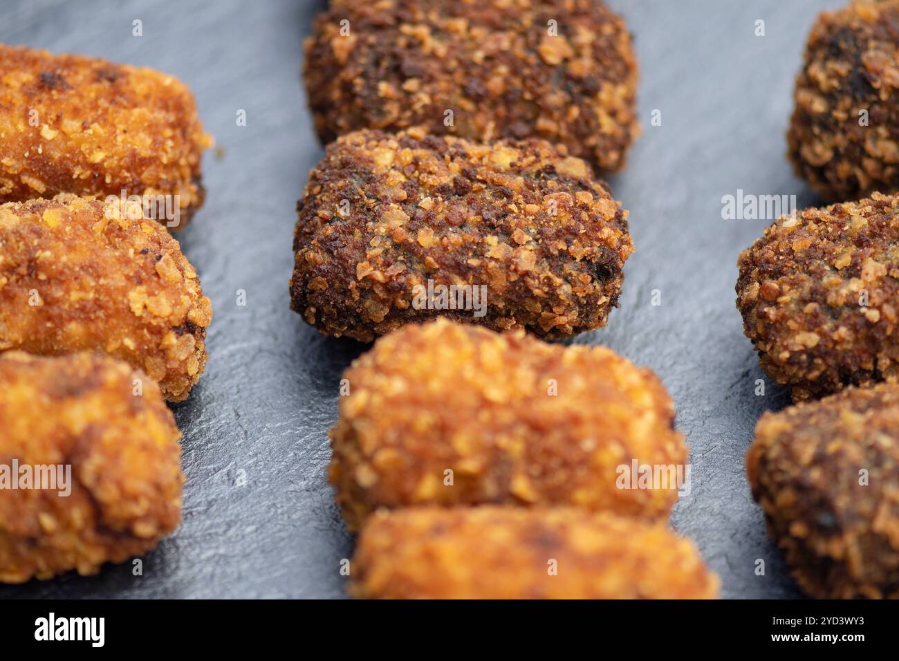 Freshly prepared homemade Spanish croquettes served on a dark slate ...