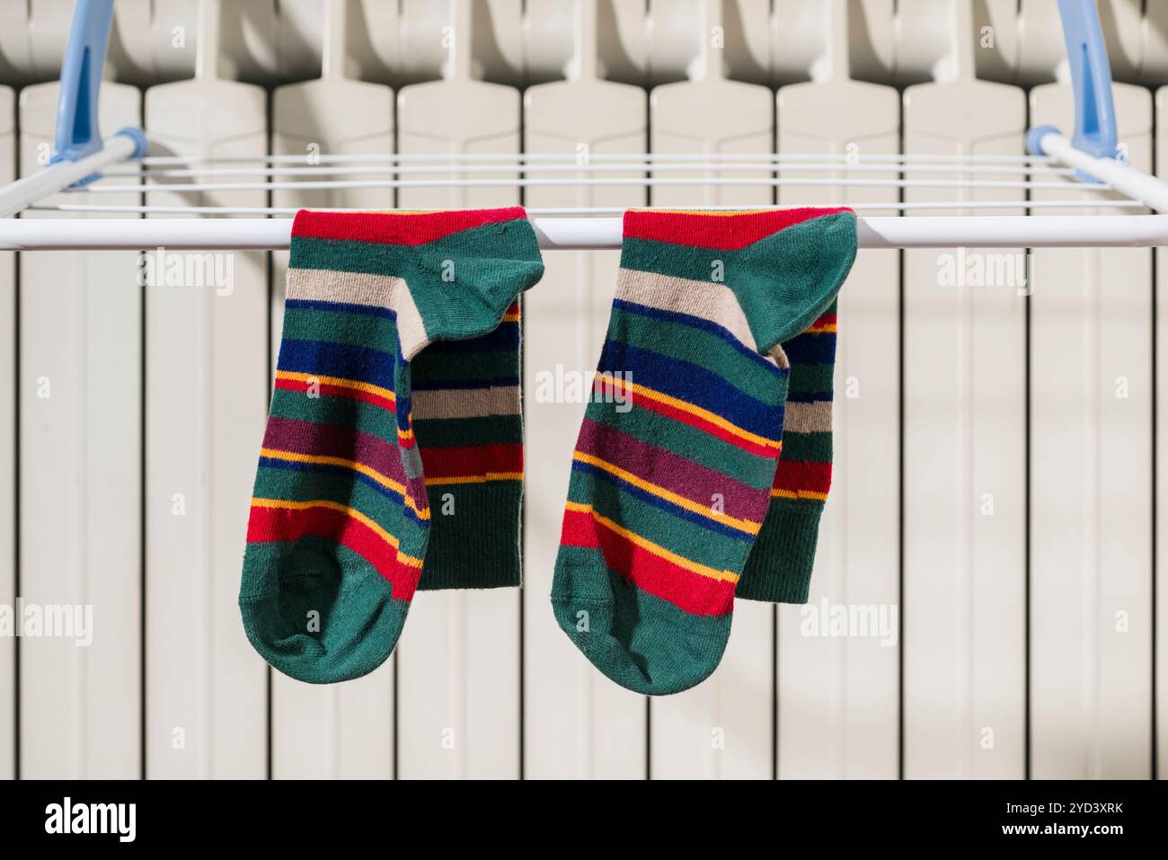 Colorful socks hanging on the clothesline drying on the radiator at ...