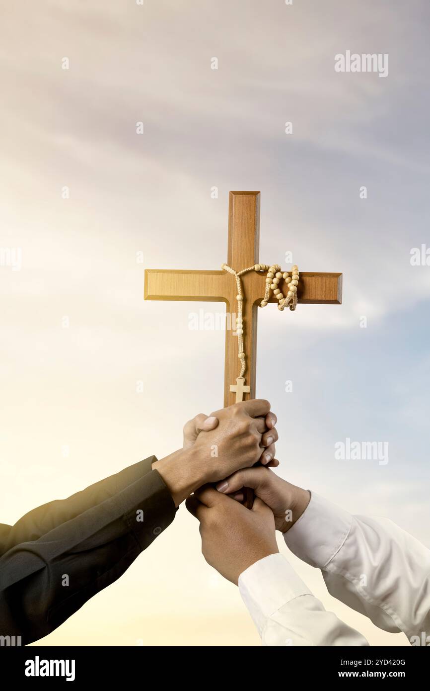 Man holding a religion cross with rosary beads together with sunlight ...