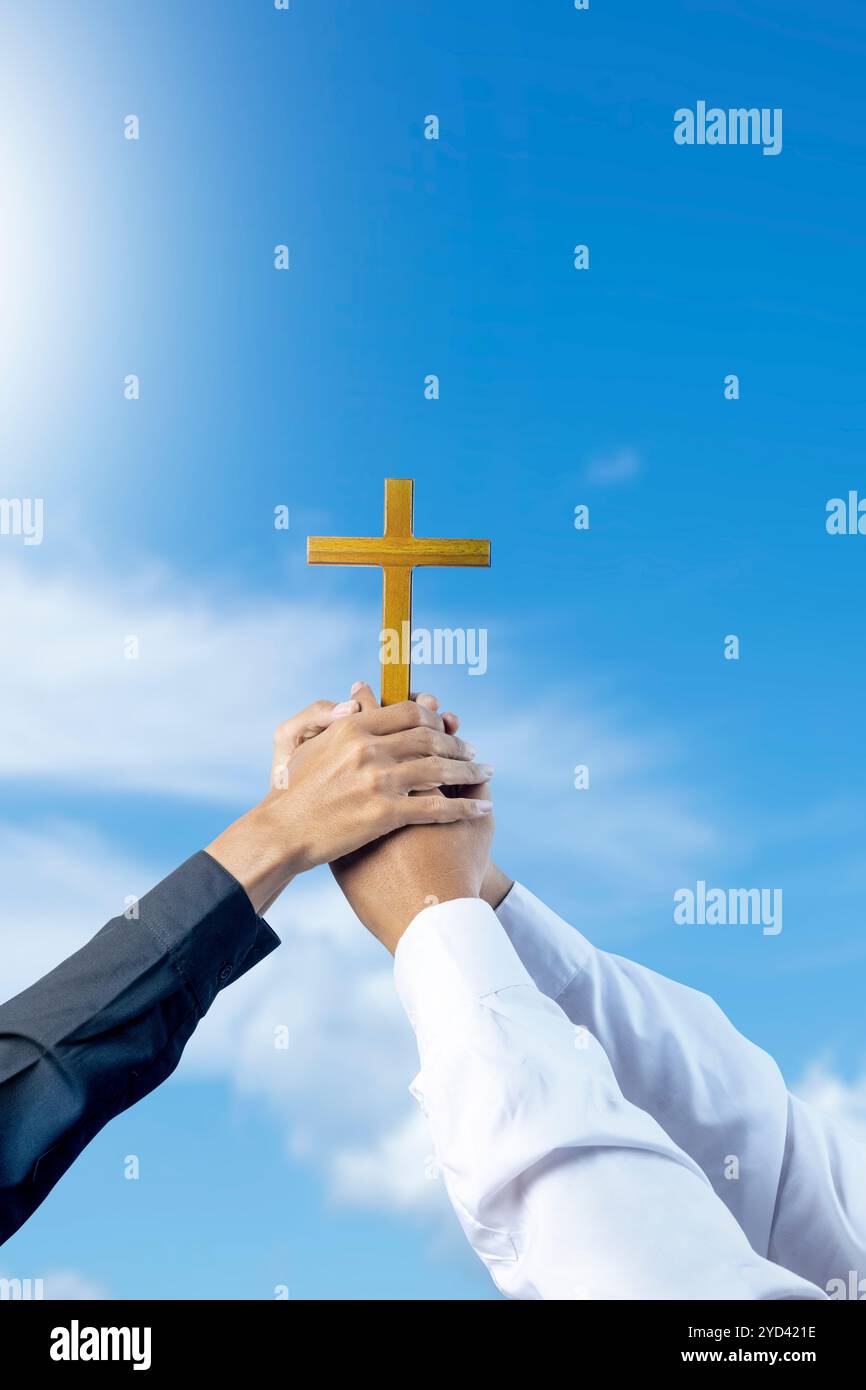 Man holding a religion cross together with blue sky background. Symbol ...
