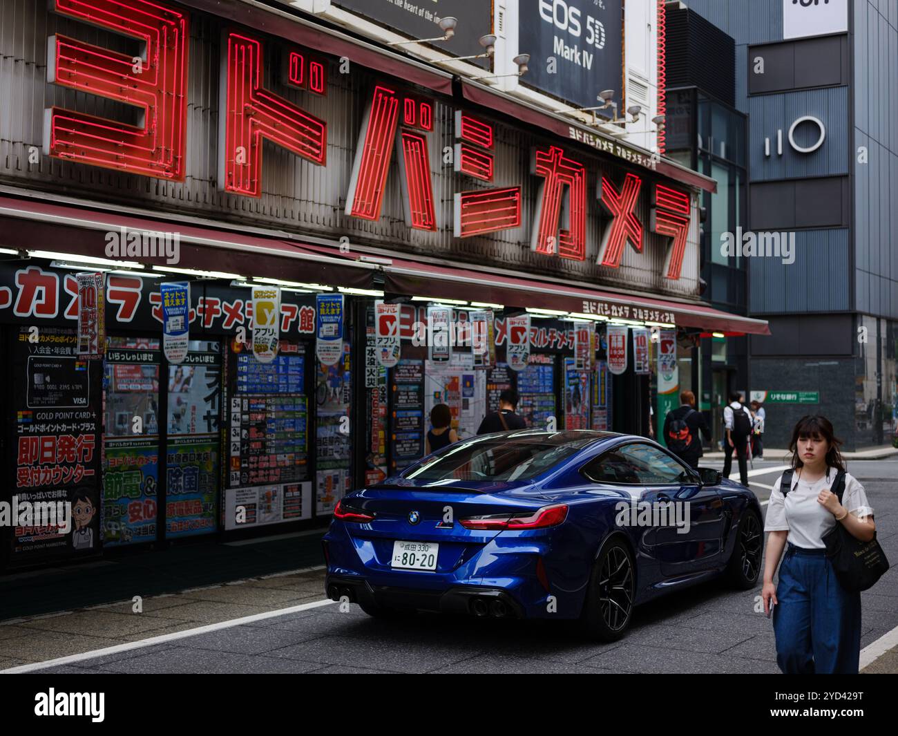 A car passing an electronics store in the Akihabara district of Tokyo ...
