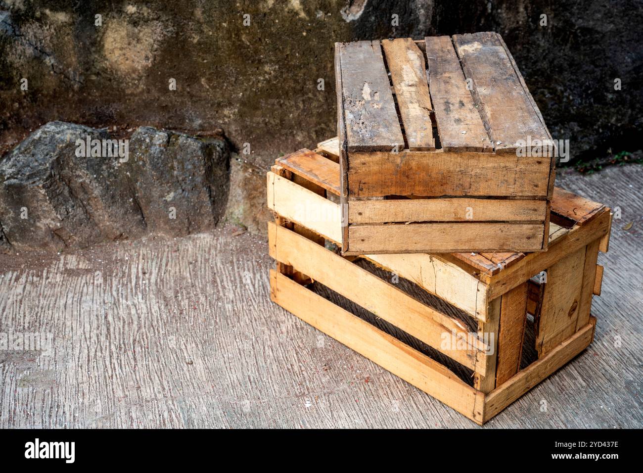 Pile of wooden crate sitting on a concrete floor with stone wall ...