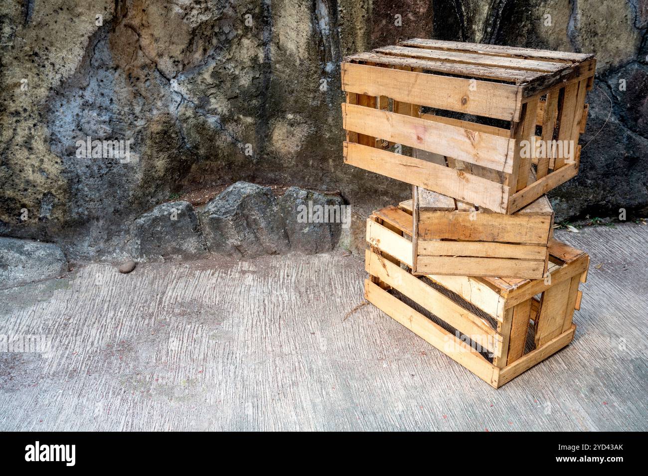 Pile of wooden crate sitting on a concrete floor with stone wall ...