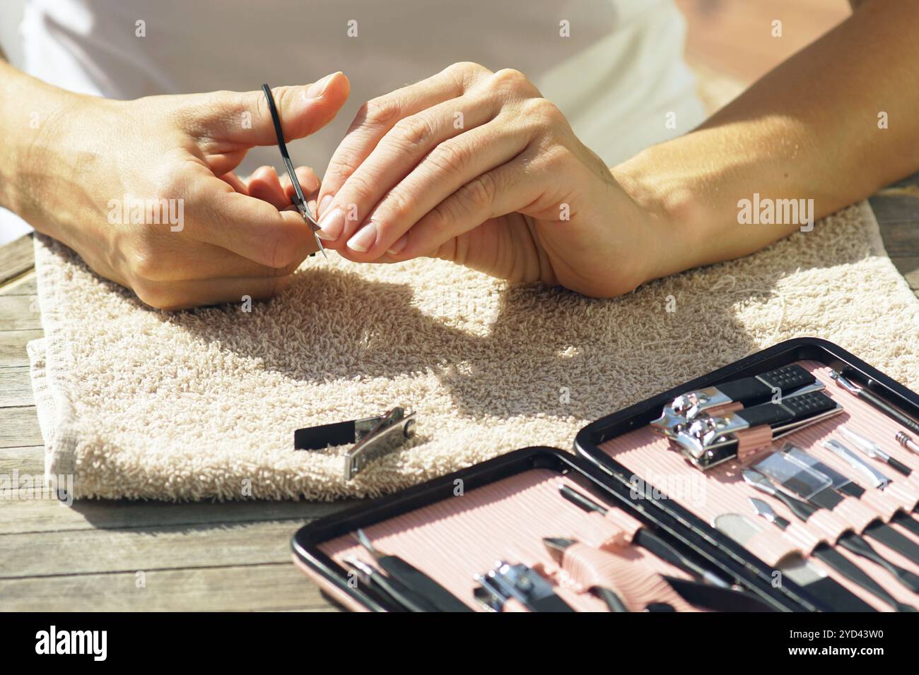 Girl trims her left hand nails with manicure scissors, close-up. Body ...